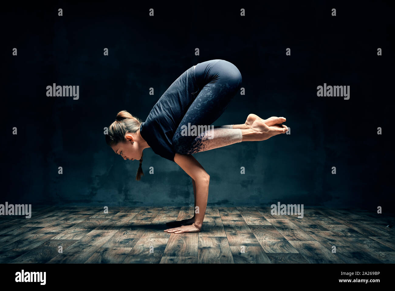 Young woman practicing yoga doing forearm stand crane pose asana in ...
