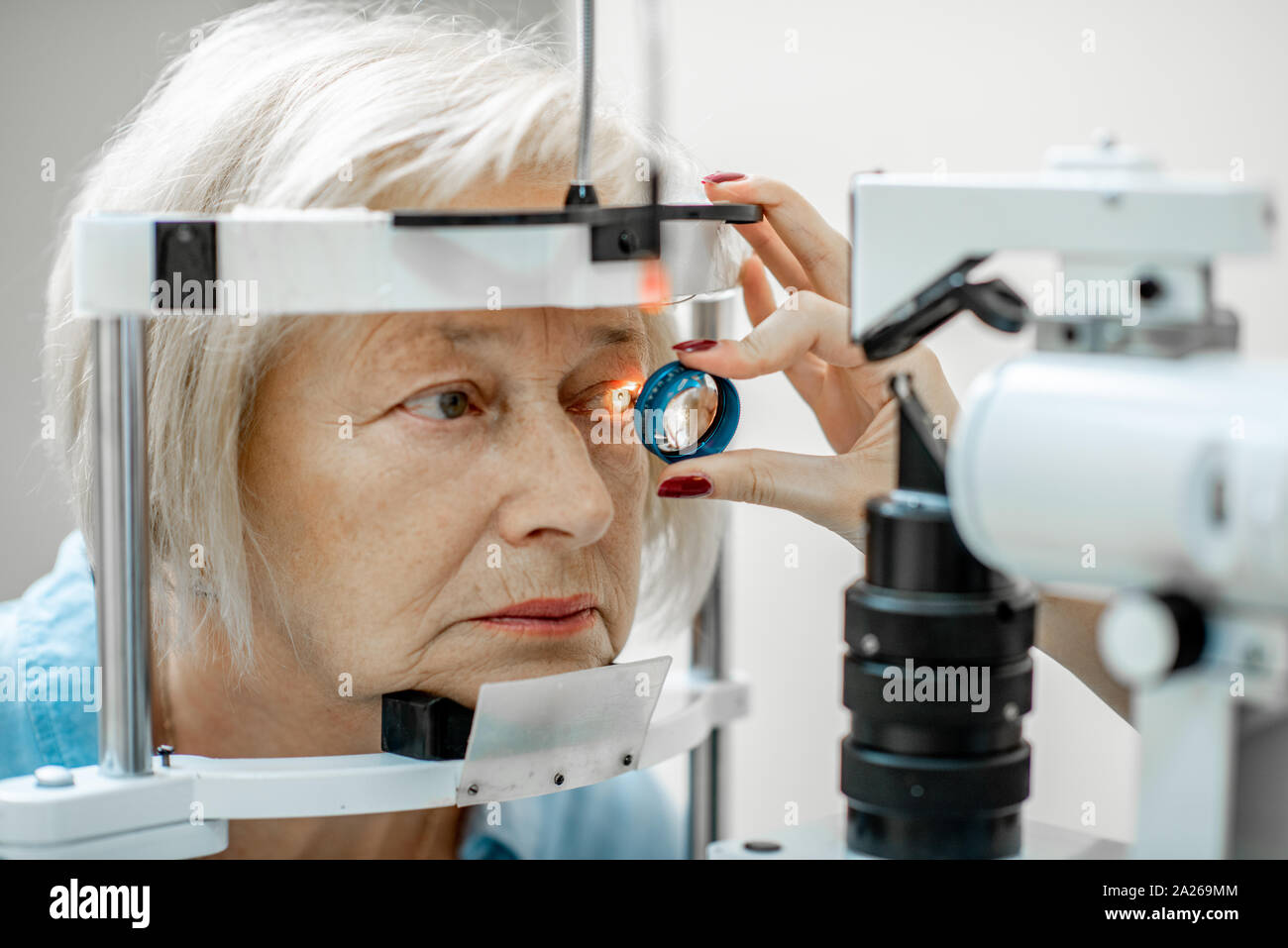 Senior woman during a medical eye examination with microscope in the ...