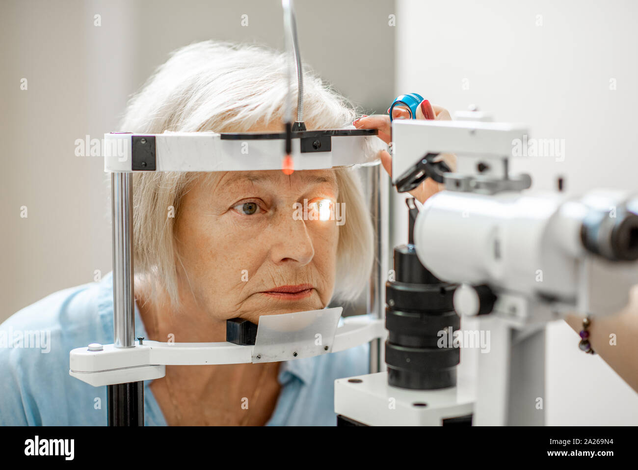 Senior woman during a medical eye examination with microscope in the ...