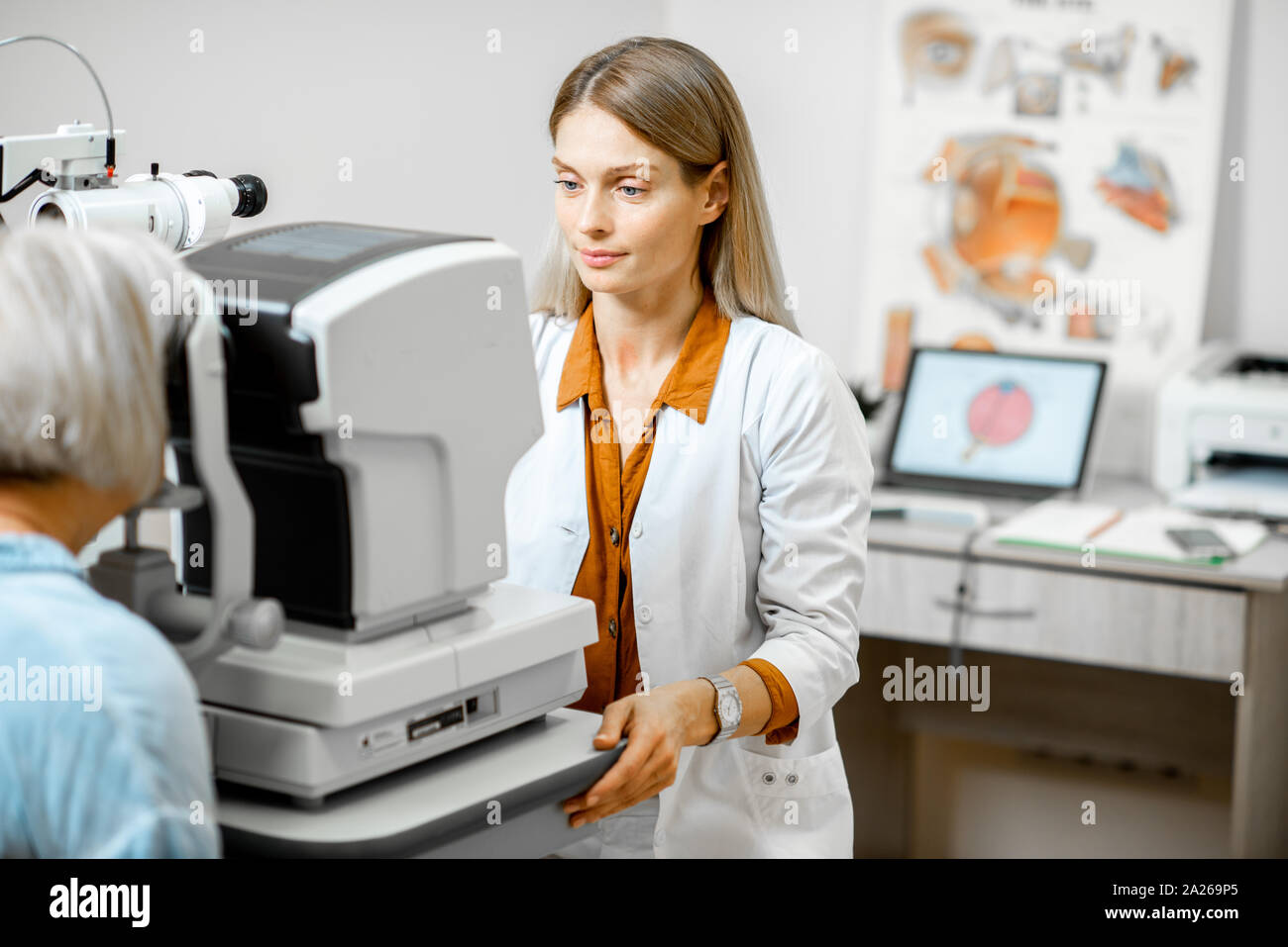 Ophthalmologist examining eyes of a senior patient using digital ...