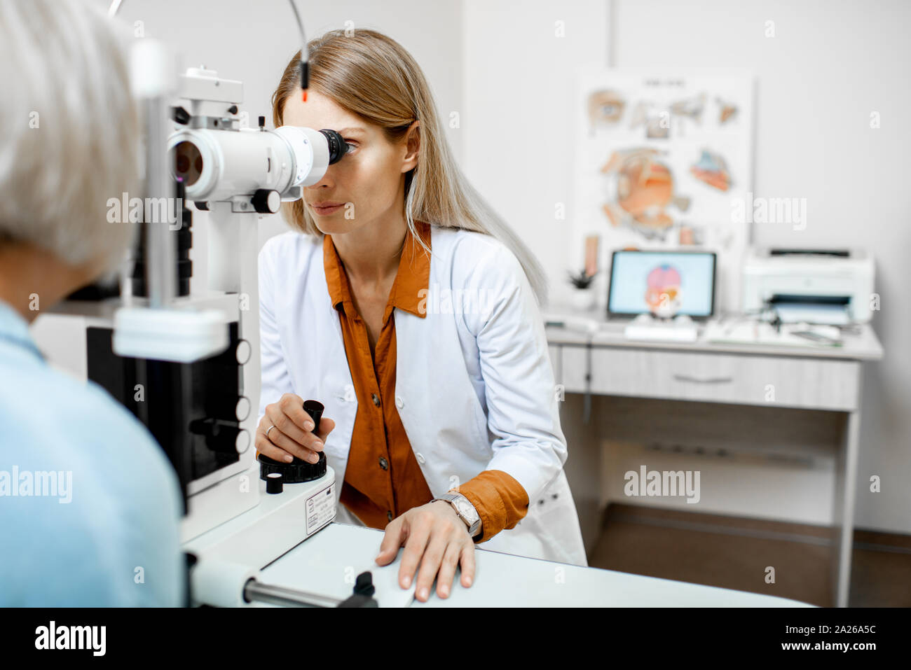 Ophthalmologist examining eyes of a senior patient using microscope ...