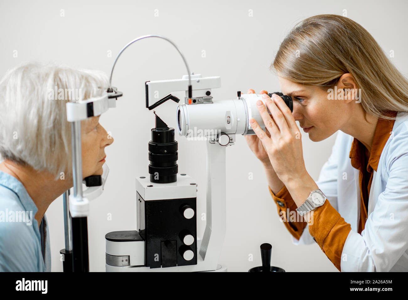 Ophthalmologist examining eyes of a senior patient using microscope ...