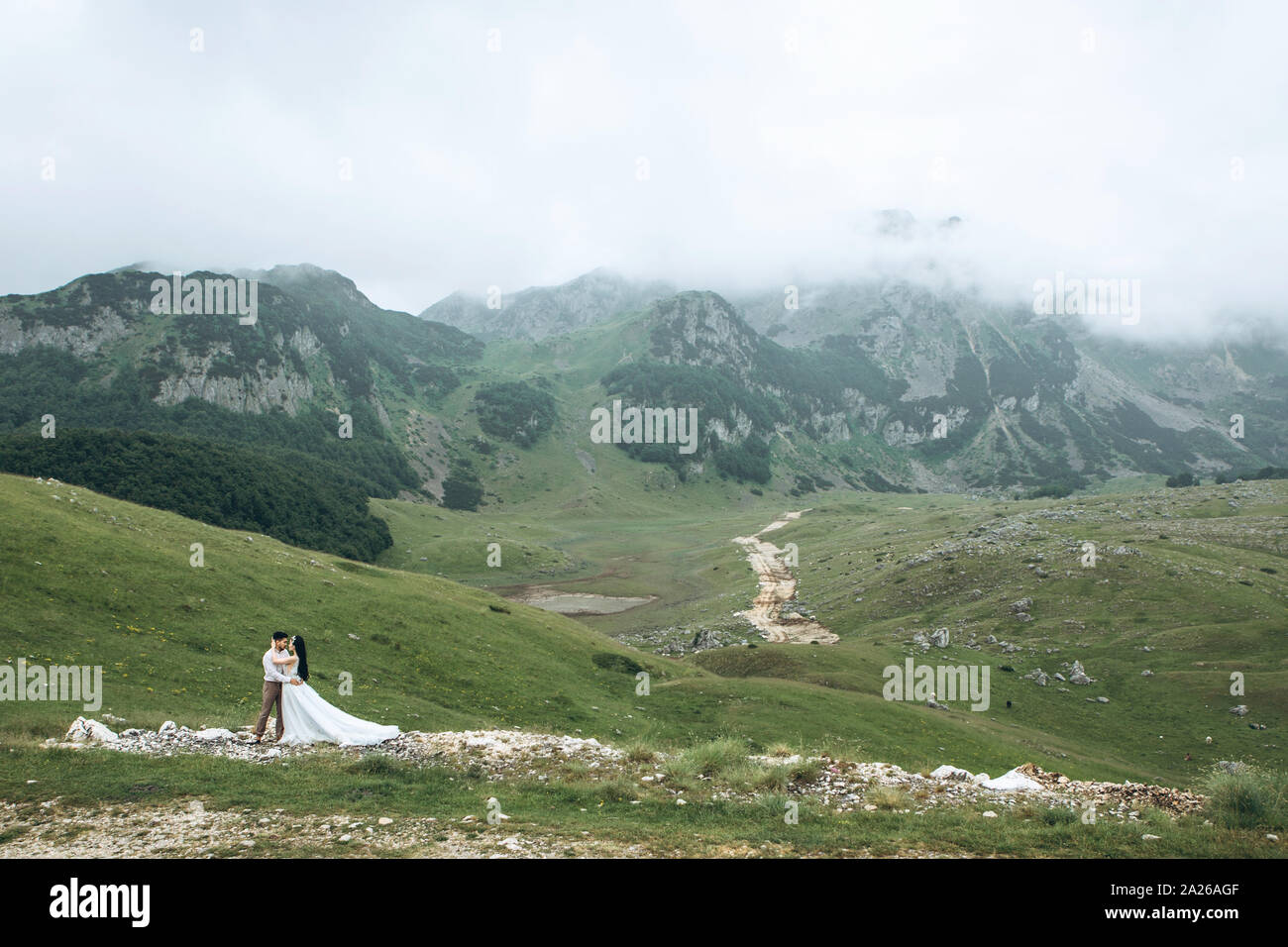 Groom with a bride or couple on a background of a beautiful mountain ...