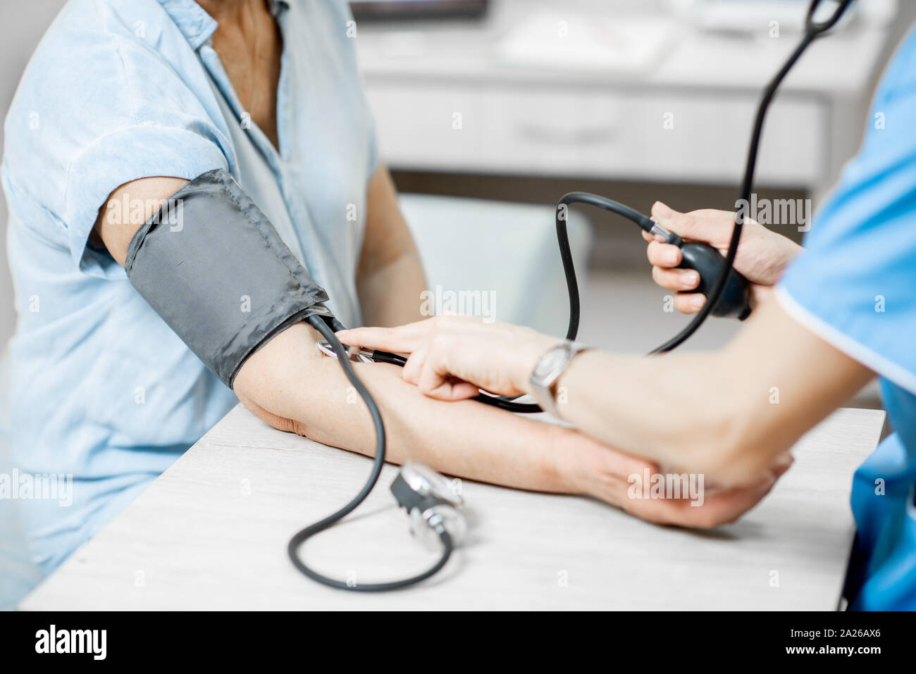 Nurse measuring blood pressure of a senior woman patient during an ...
