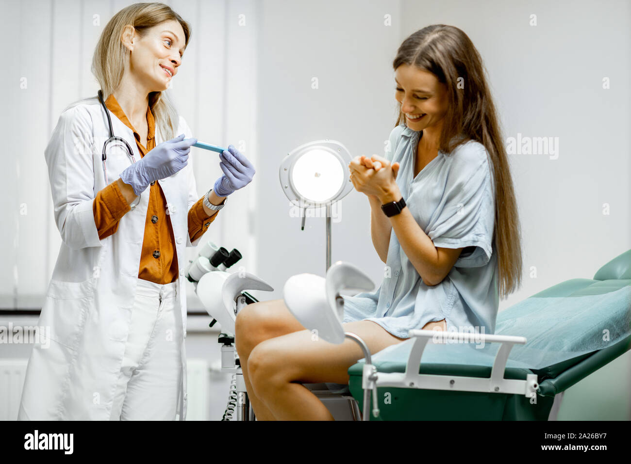Gynecologist looking at pregnancy test during a medical examination ...