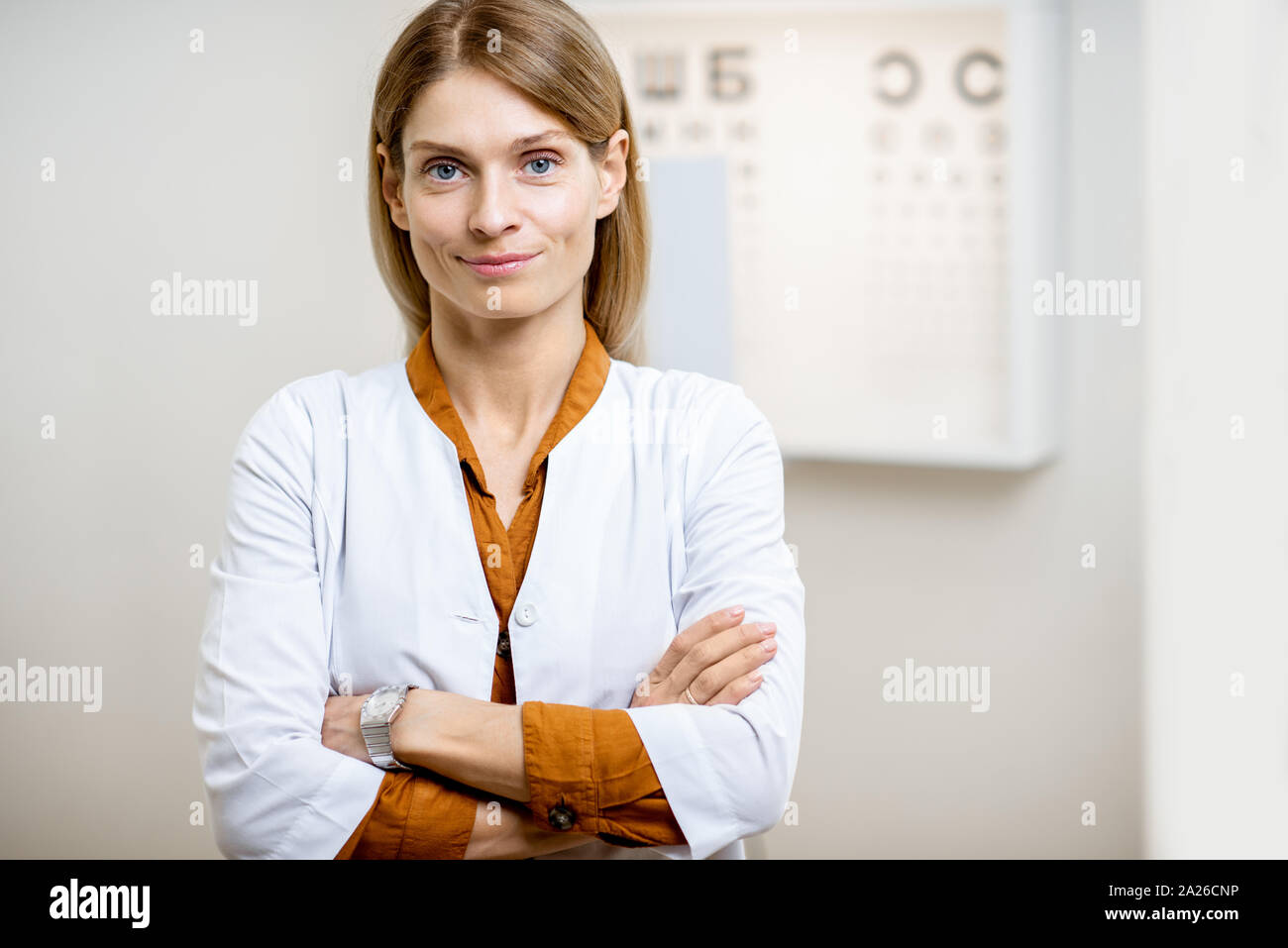 Portrait of a confident ophthalmologist in medical uniform standing in ...