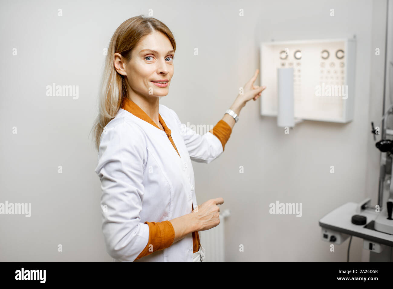 Portrait of a confident ophthalmologist in medical uniform standing in ...