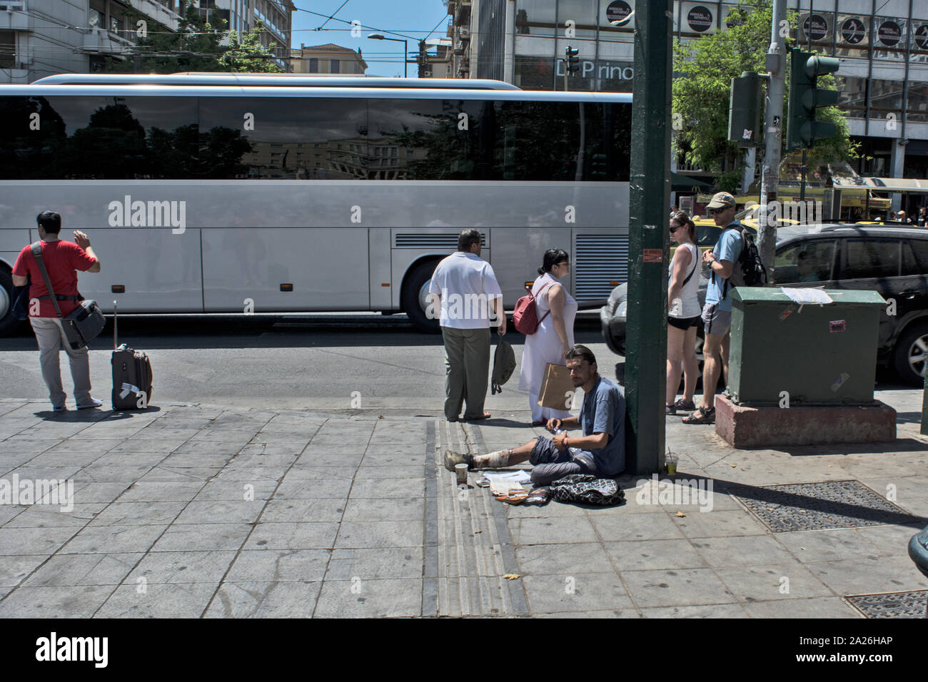 ATHENS, GREECE, JUNE 04, 2016 A homeless man - a beggar sits on a ...