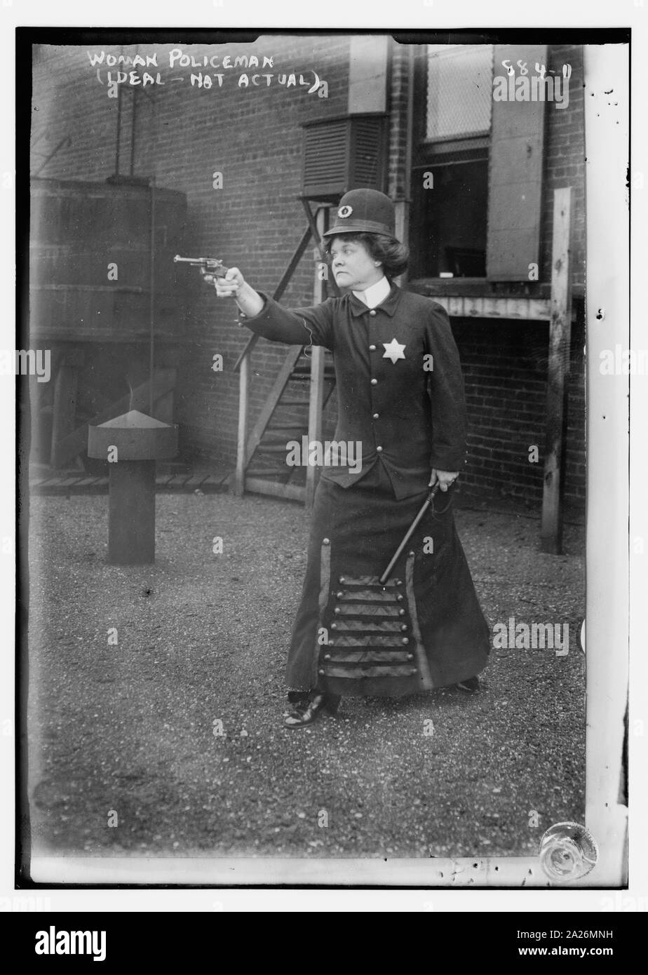Policewoman posing with pointed gun and bobby stick Stock Photo - Alamy