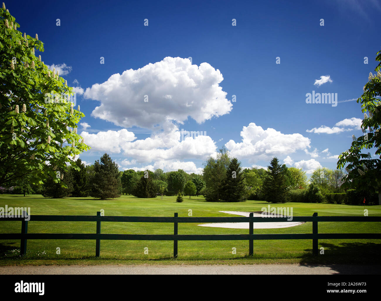 Bunker on golf course, fence and cloudy sky Stock Photo - Alamy