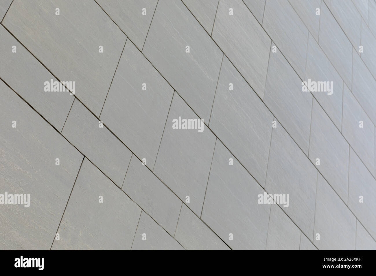 Low angle view of wall with gray smooth tiles of different shape ...