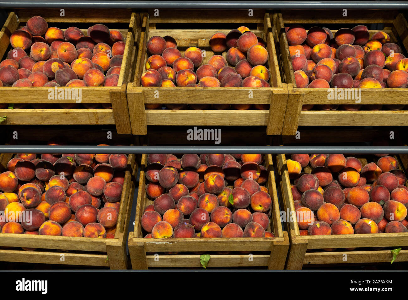 Wooden lug boxes with soft and mellow peaches on counter in supermarket ...