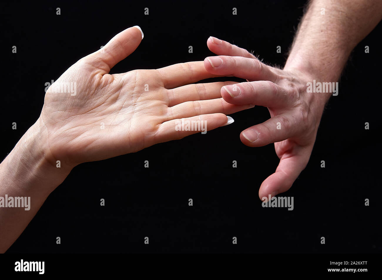 Male and female hands together showing emotions on black background ...