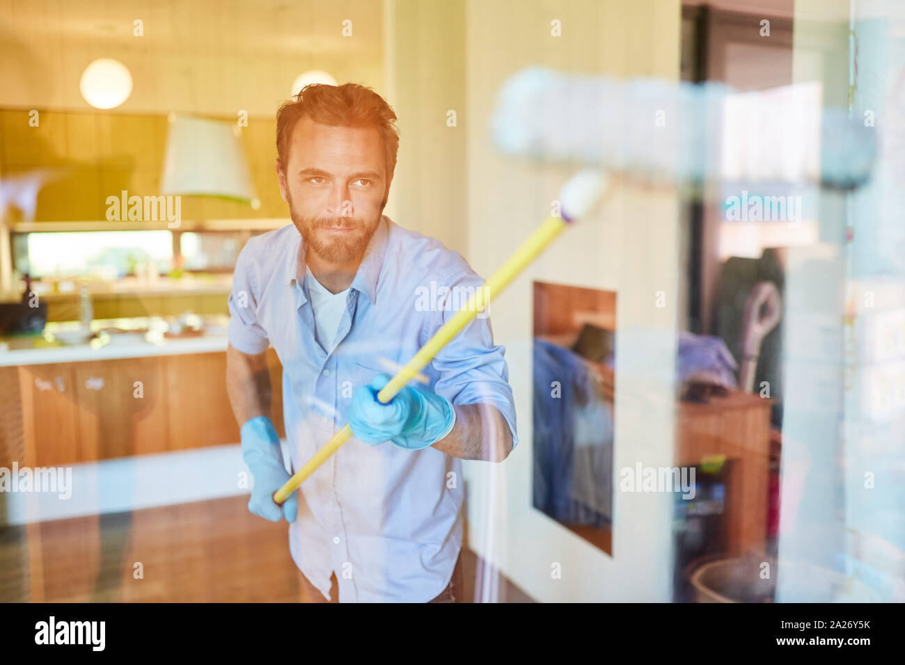 Man as a window cleaner or houseman cleaning the streak-free window ...