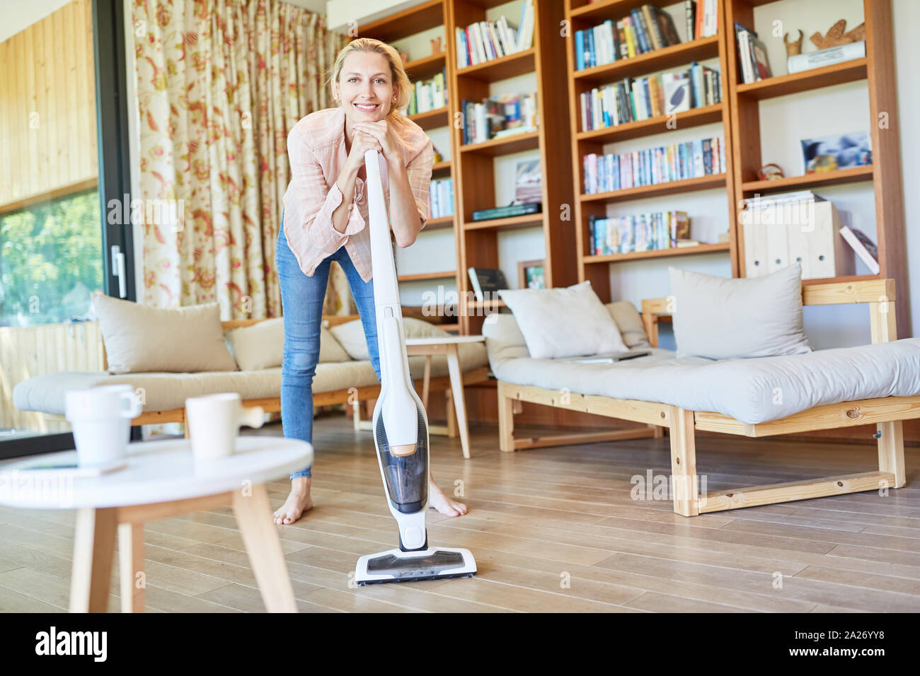 Housewife as a cleaning lady with vacuum cleaner during spring cleaning ...