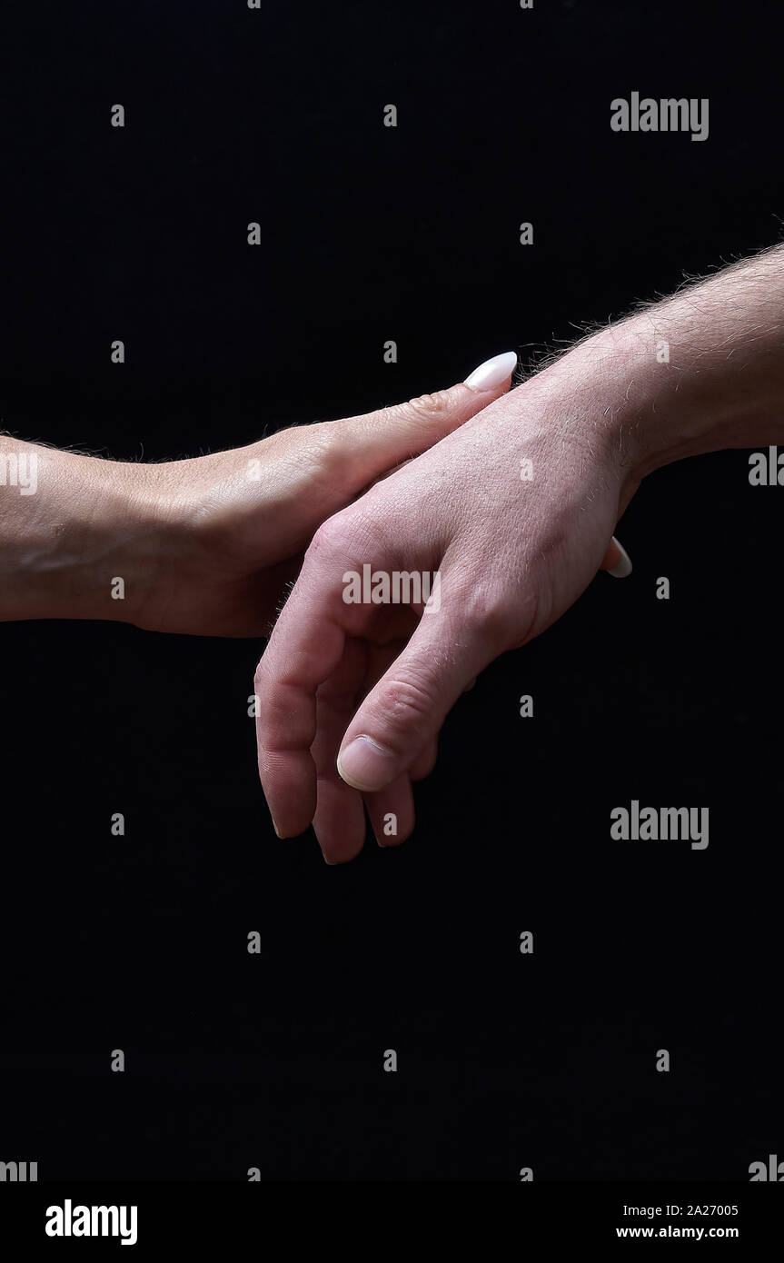 Male and female hands together showing emotions on black background ...