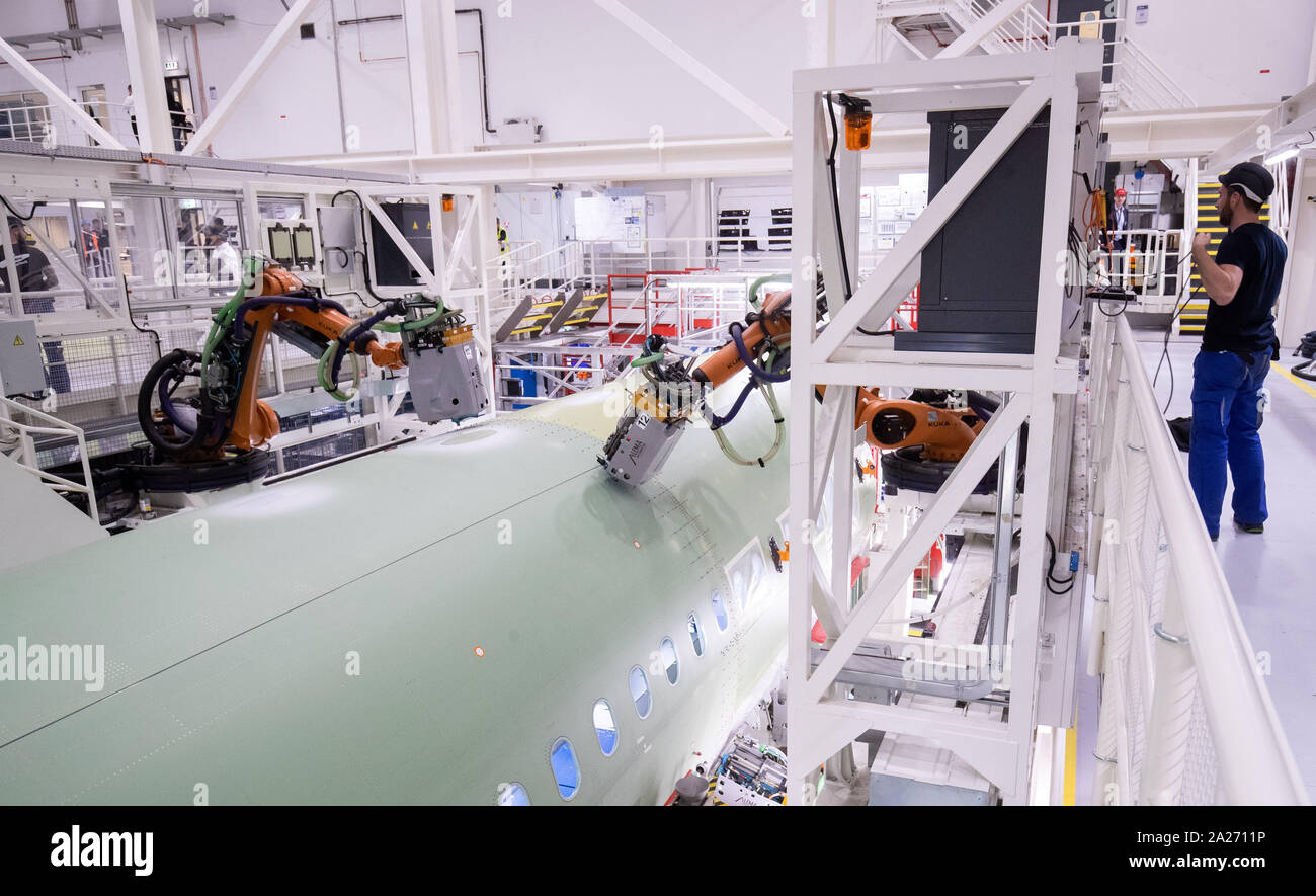 Hamburg, Germany. 01st Oct, 2019. An employee observes two robots ...