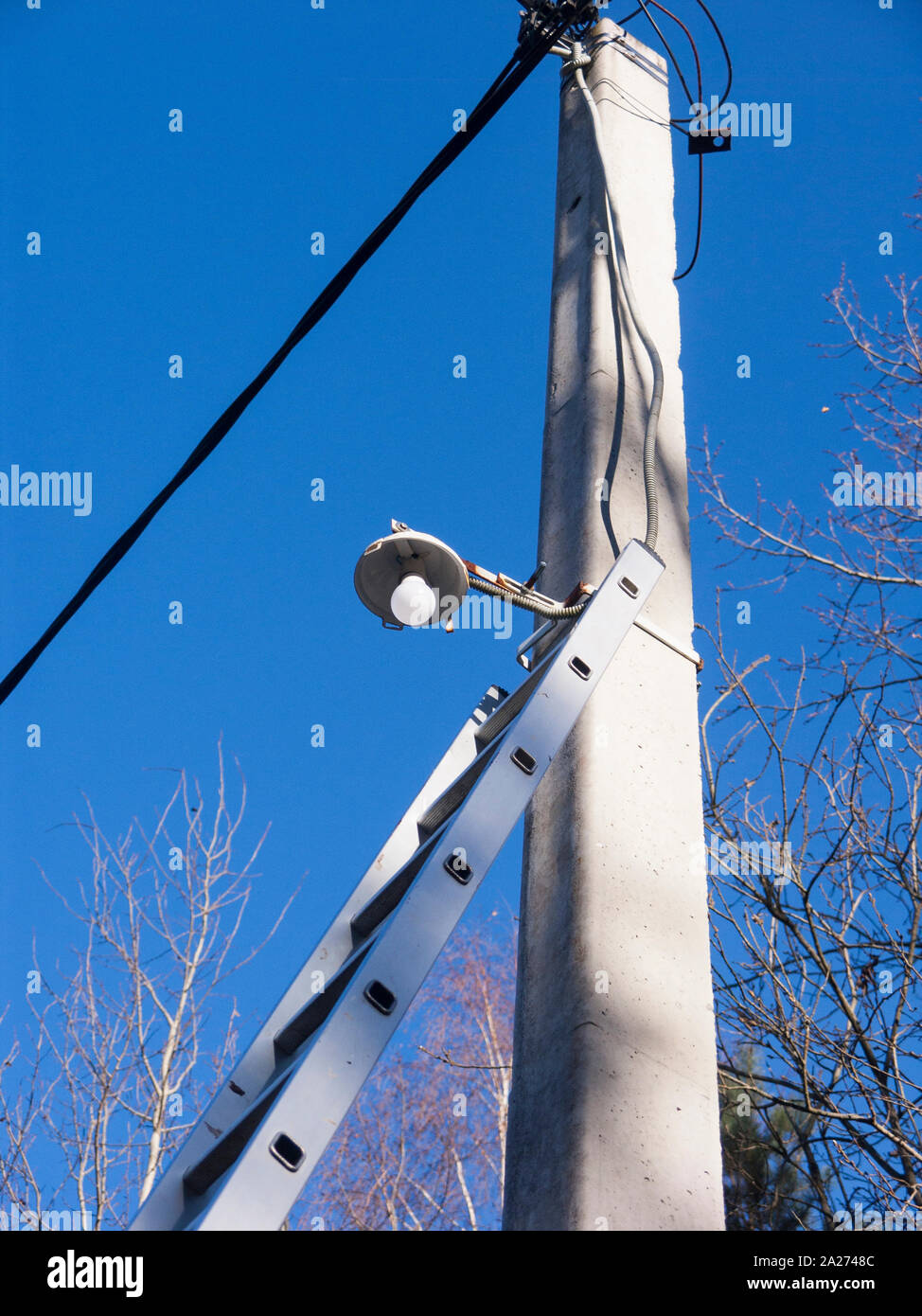 Expandable ladder leaning against the electric post for lamp ...