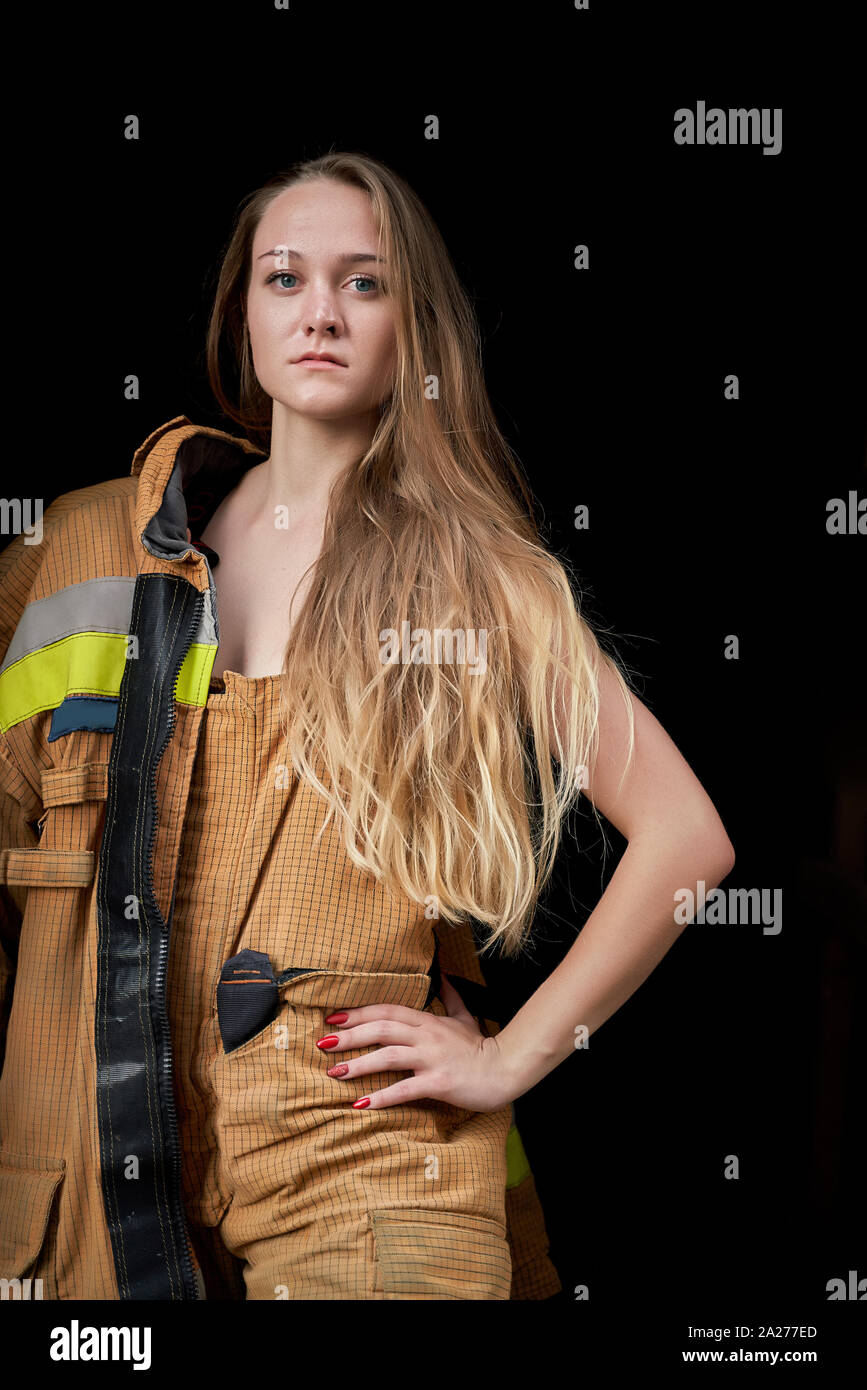 Picture of young firefighter woman in overalls on black empty ...