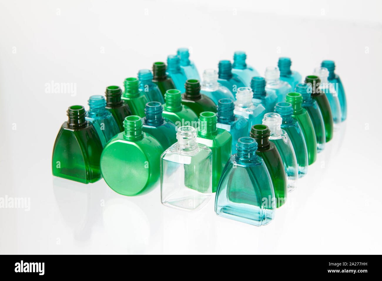 Side view of a group of small green colored plastic bottles well ...