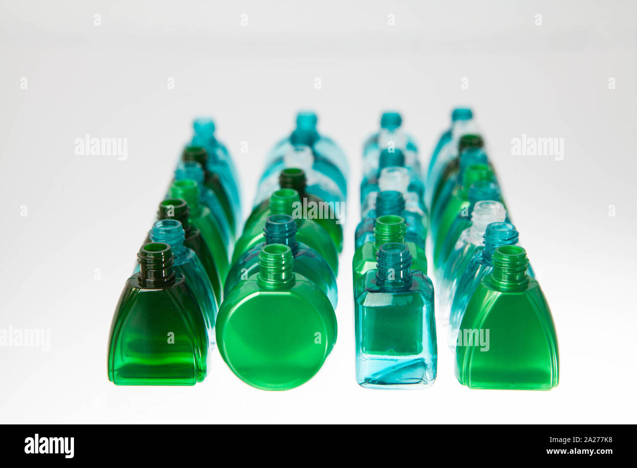 Frontal view of a group of small green colored plastic bottles well ...