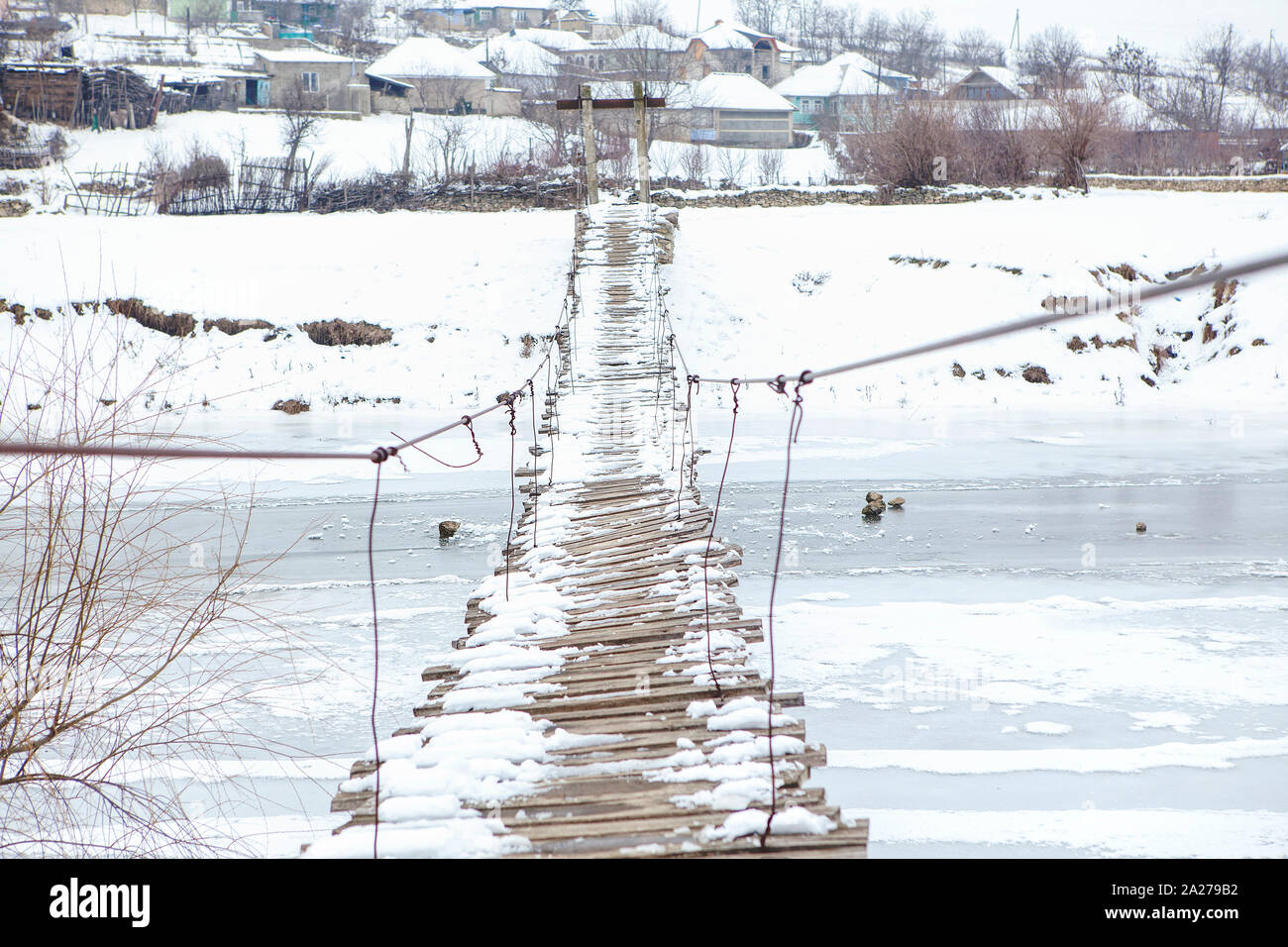 hanging wooden bridge over frozen river Stock Photo - Alamy