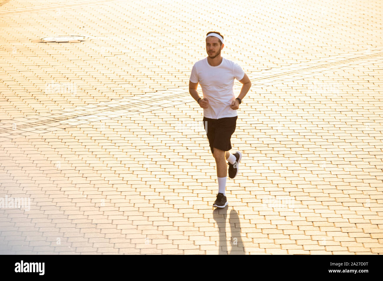 Attractive fit man running in the city at sunset. Fitness, workout ...