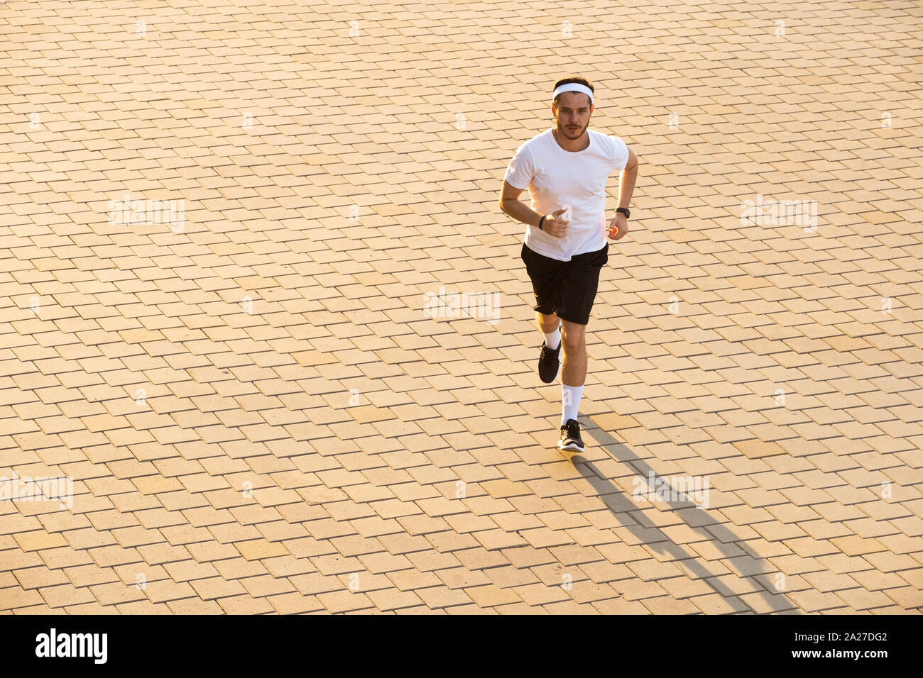 Attractive fit man running in the city at sunset. Fitness, workout ...