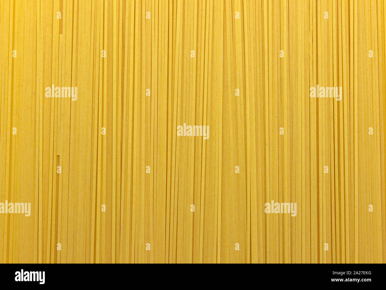 Thin pasta arranged in rows. Yellow italian pasta. Long spaghetti. Raw ...
