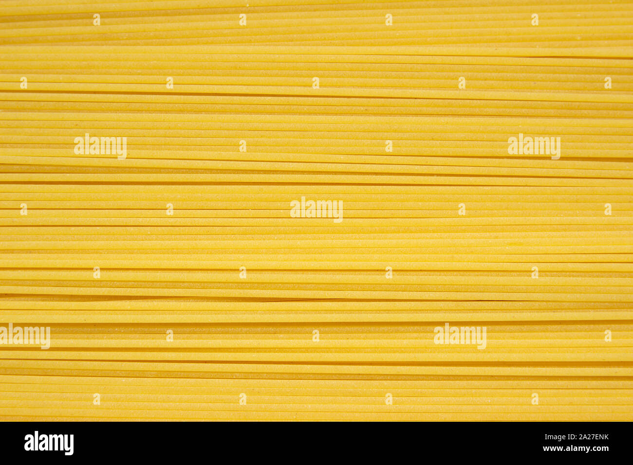 Thin pasta arranged in rows. Yellow italian pasta. Long spaghetti. Raw ...