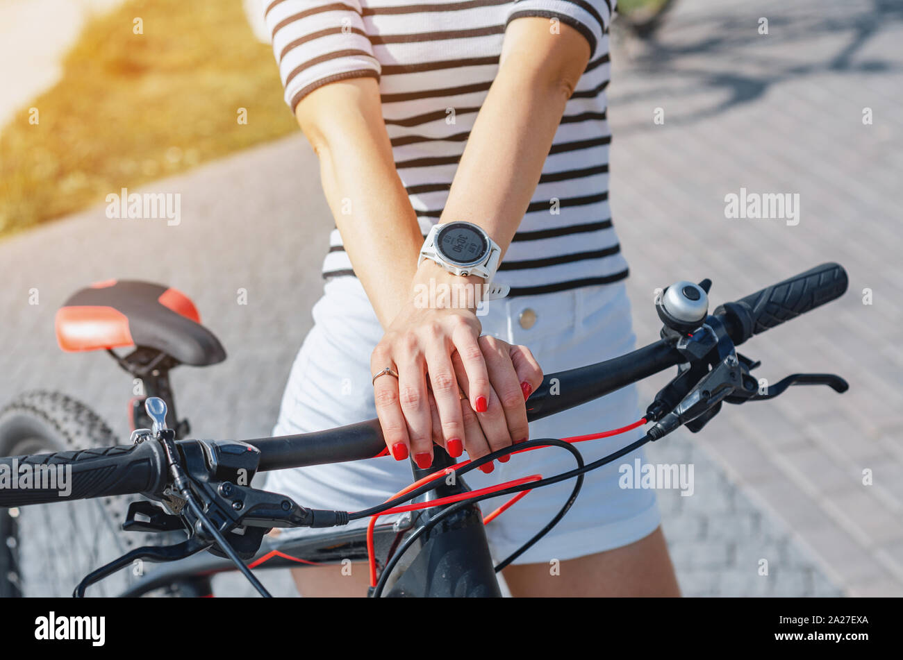 Woman's hand on bicycle handlebar, white smart watch on wrist, active ...