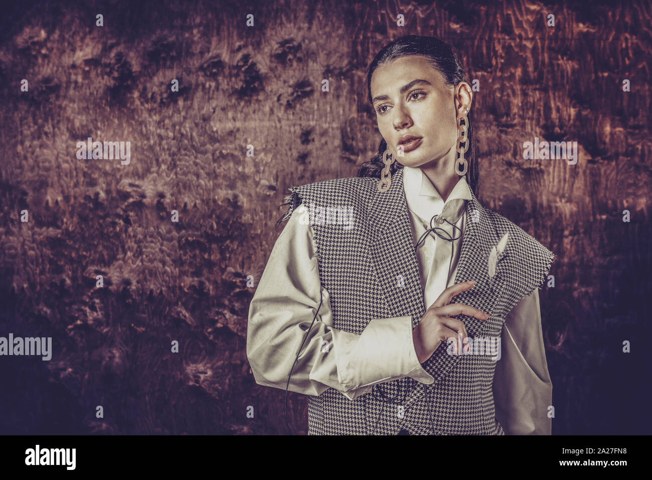 Gorgeous model wearing earring posing beside the wall Stock Photo - Alamy