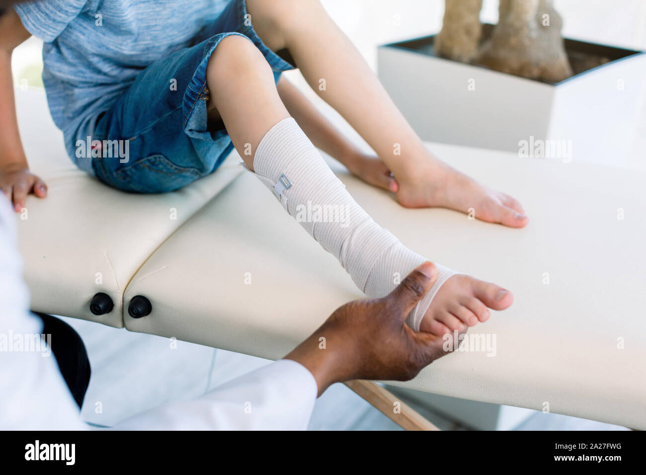cropped shot of african american doctor putting on bandage on patients ...