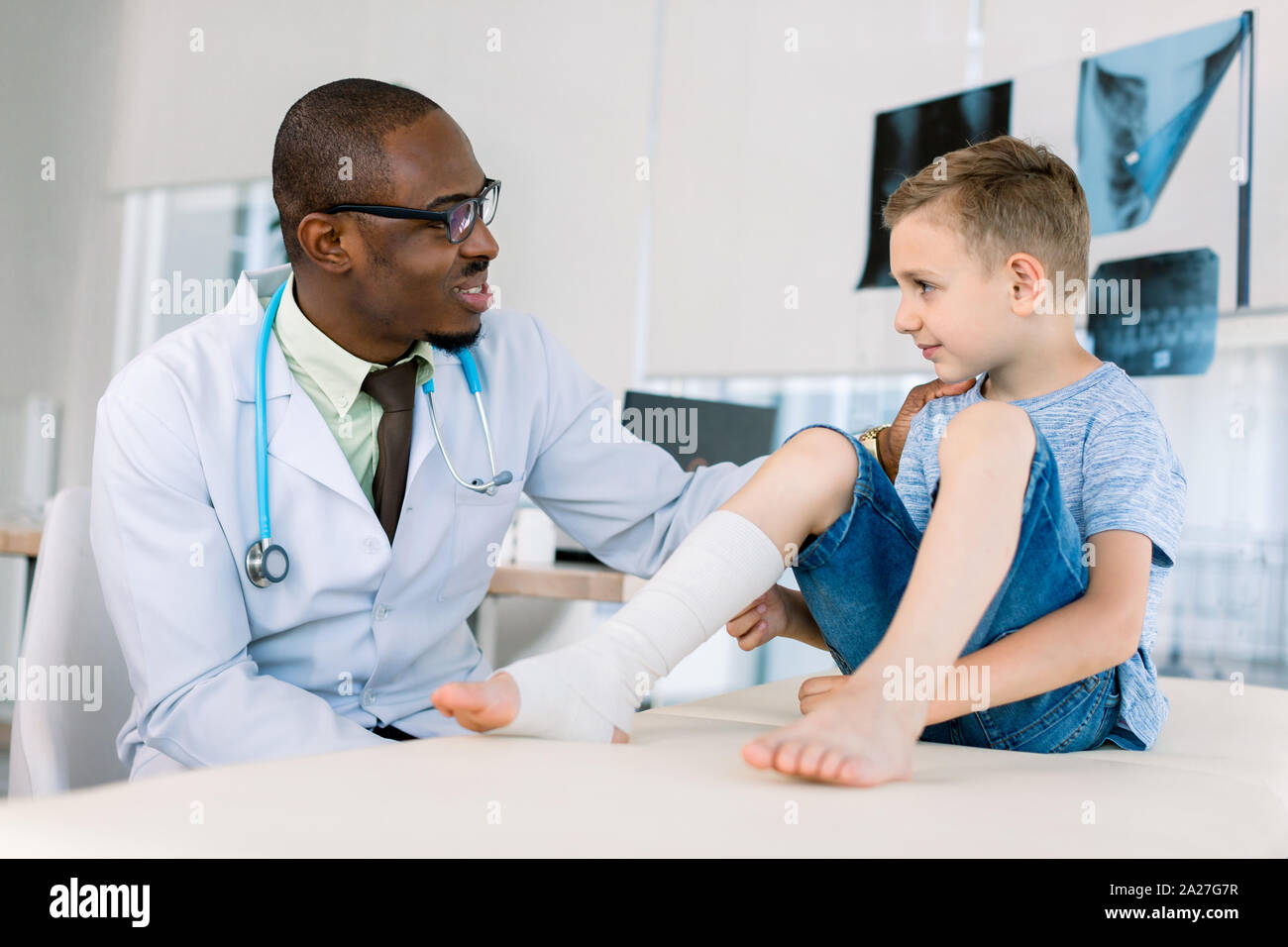 side view of african american doctor examining leg with elastic bandage ...