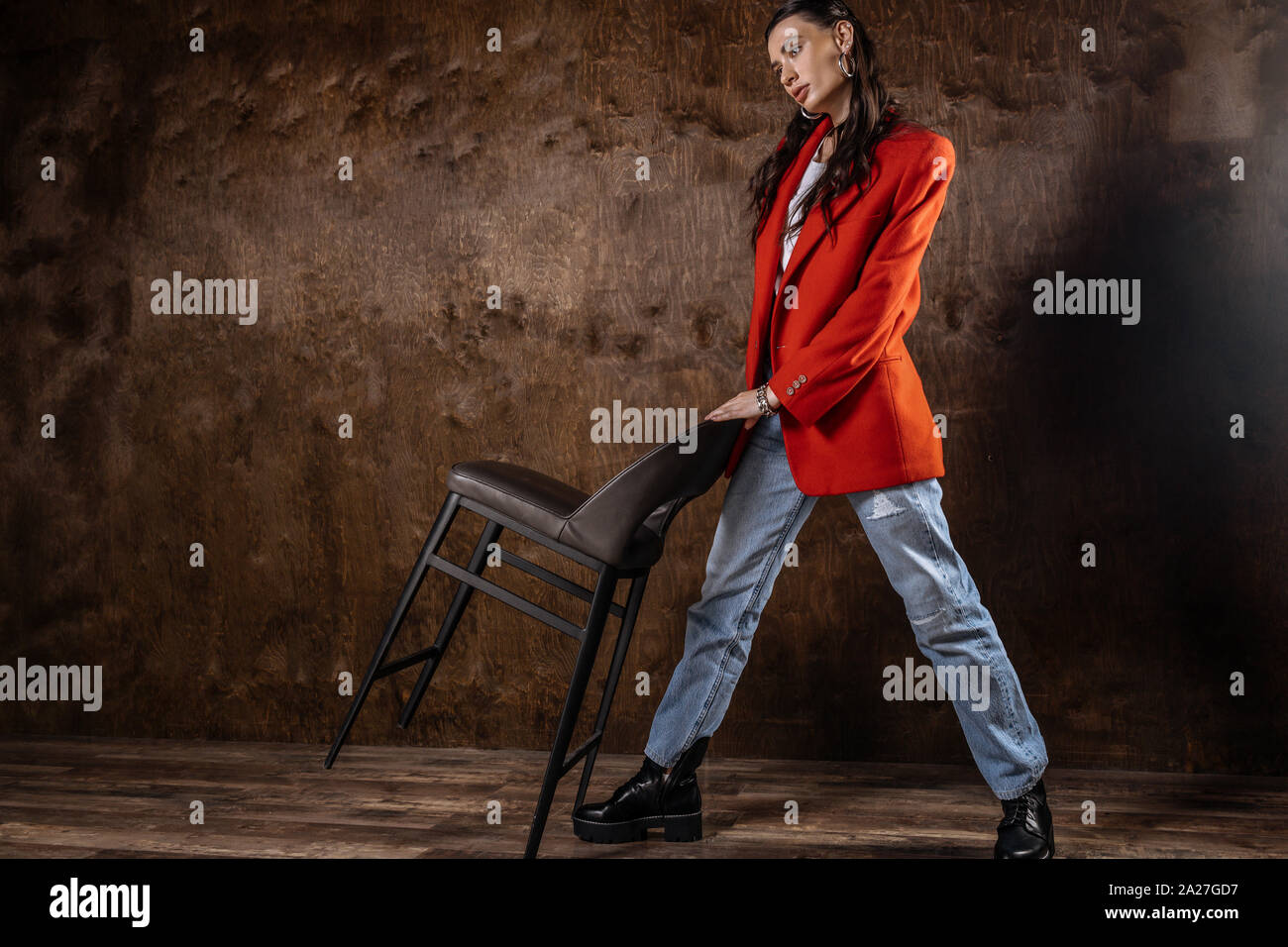 Pretty stylish lady modelling using chair as a prop Stock Photo - Alamy