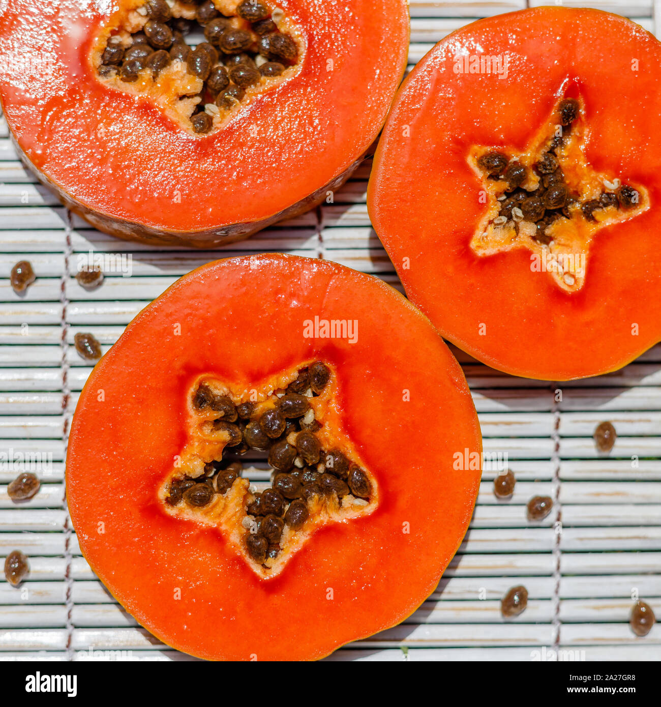 Fresh papaya cut in round pieces, with a star shape middle. Square ...