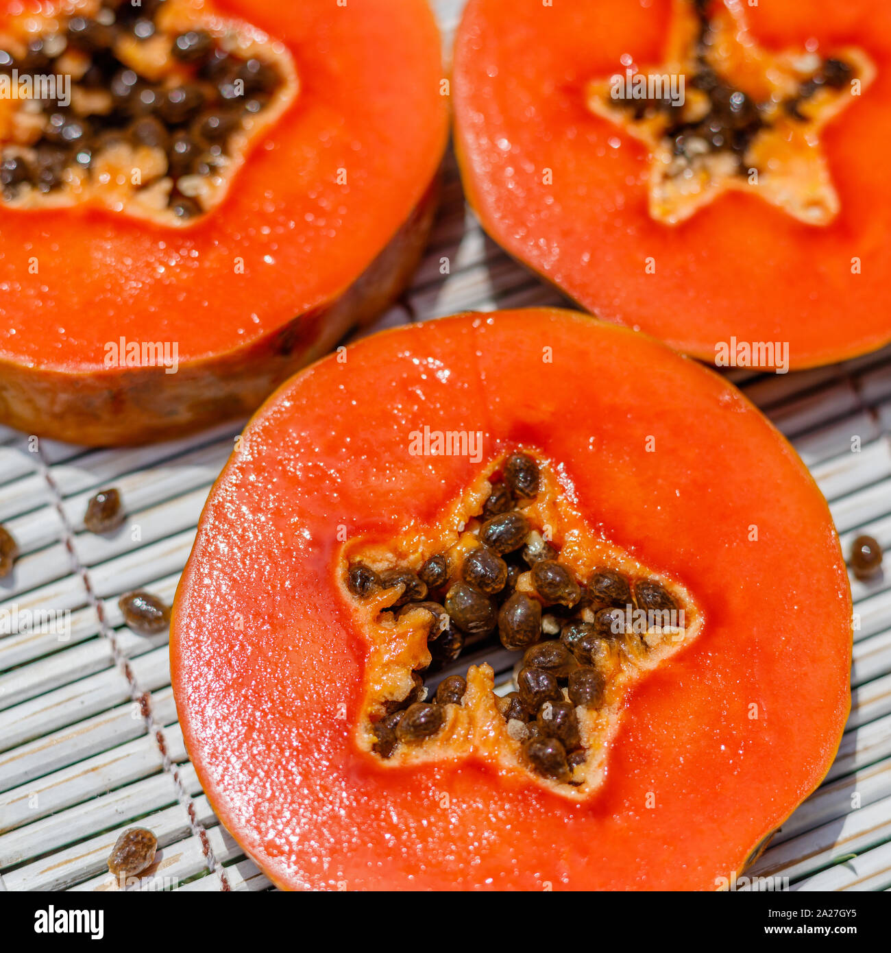 Fresh papaya cut in round pieces, with a star shape middle. Square ...