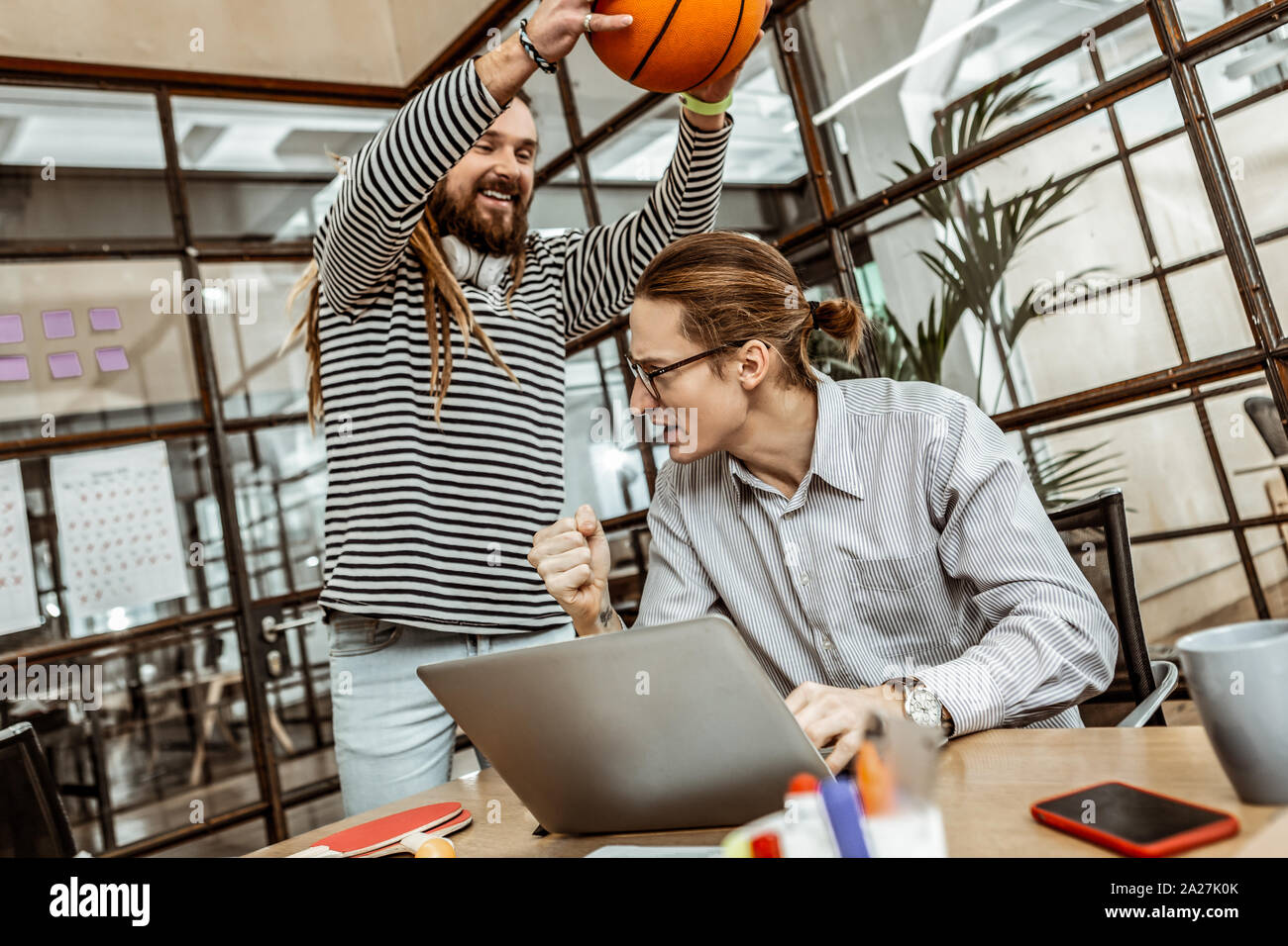 Feeling happiness. Cheerful bearded man keeping smile on his face while ...