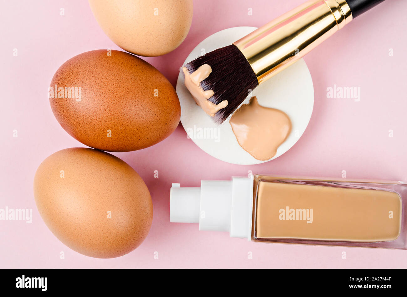 Liquid fluid foundation glass bottle on makeup sponges and egg on pink ...