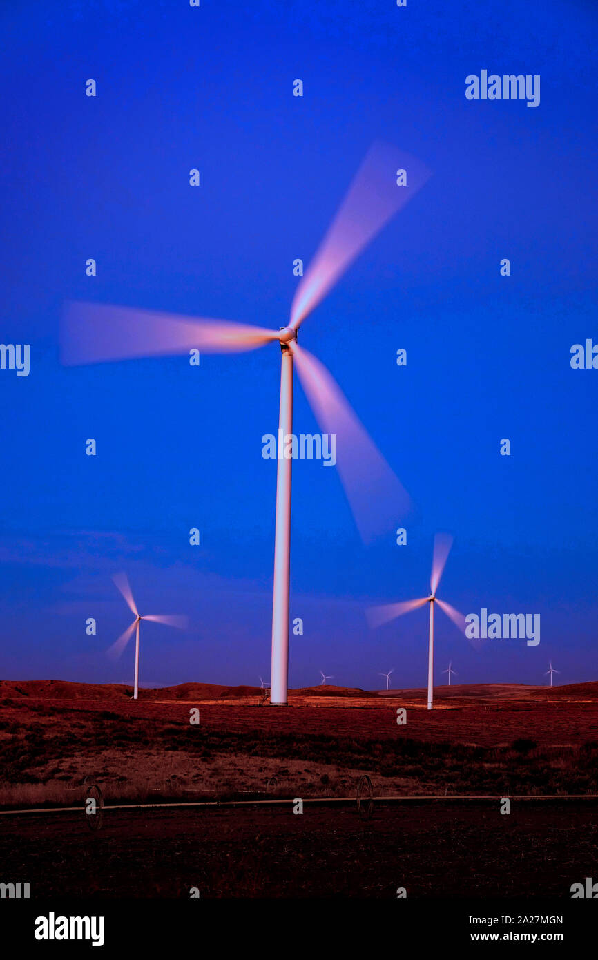Windmill wind turbines spinning fast in wind at sunset or sunrise Stock ...