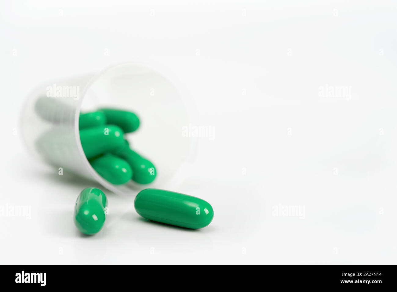 Closeup on bright green capsules with medication on white background ...