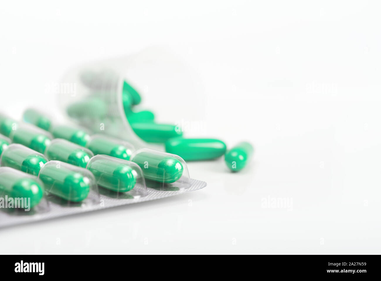 Closeup on bright green capsules with medication on white background ...