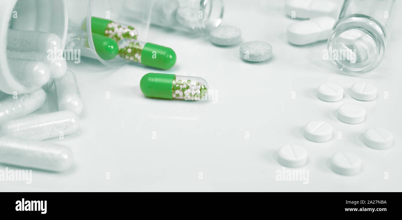Closeup on bright green capsules with medication and various white ...