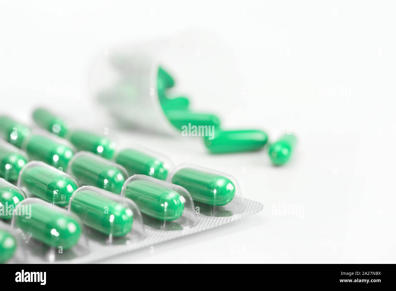 Closeup on bright green capsules with medication on white background ...