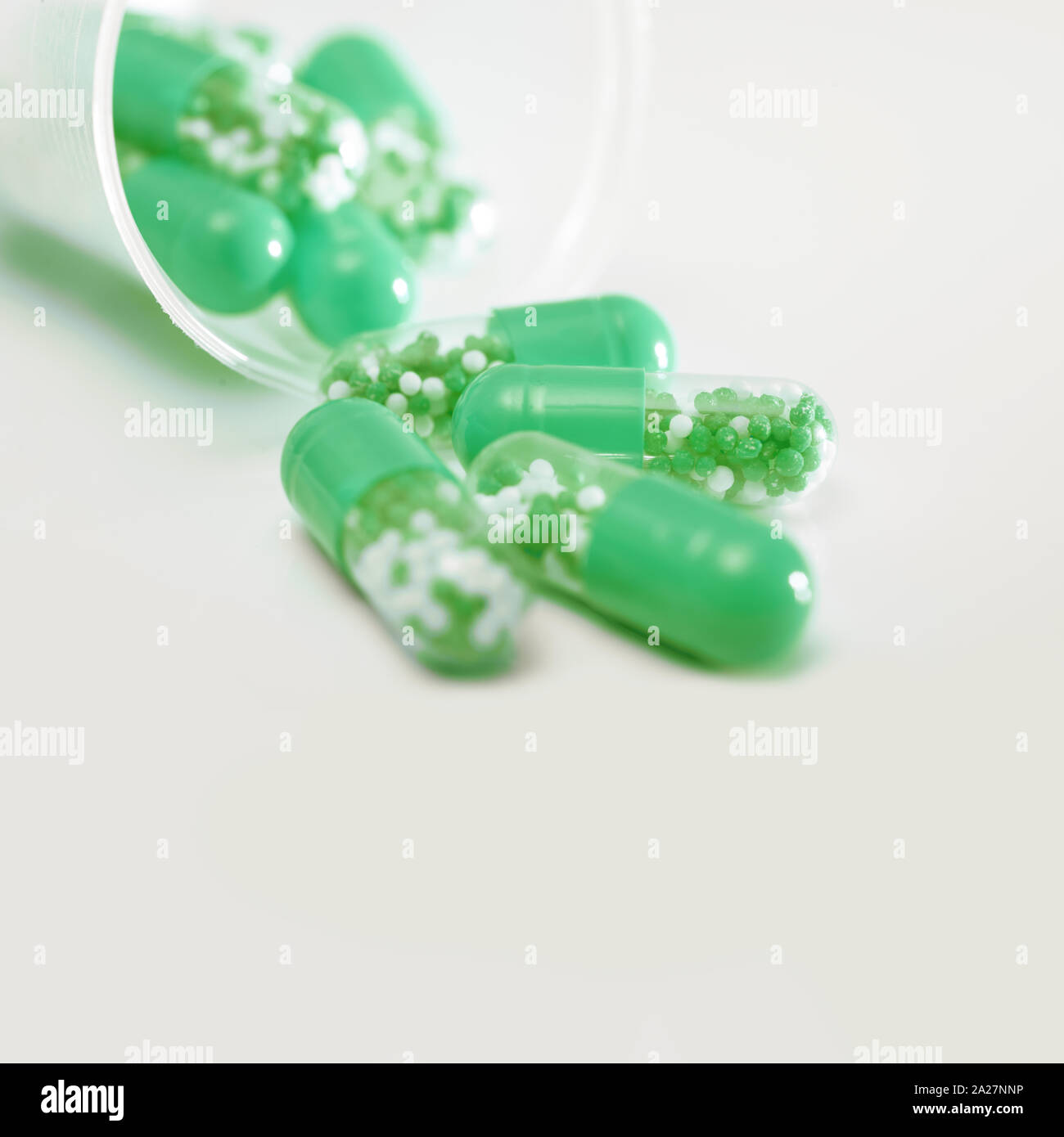 Closeup on bright green capsules with medication on white background ...