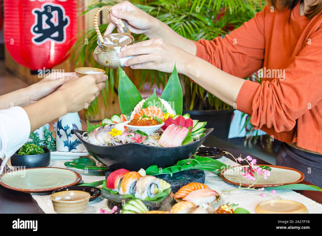 Close up women enjoy eating sashimi Japanese food in restaurant Stock ...