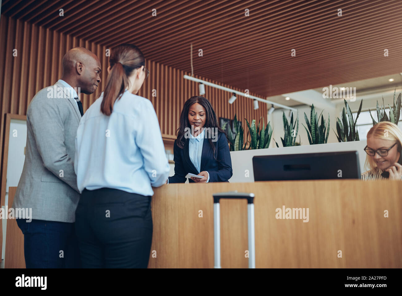 Young African American concierge working behind a reception counter ...