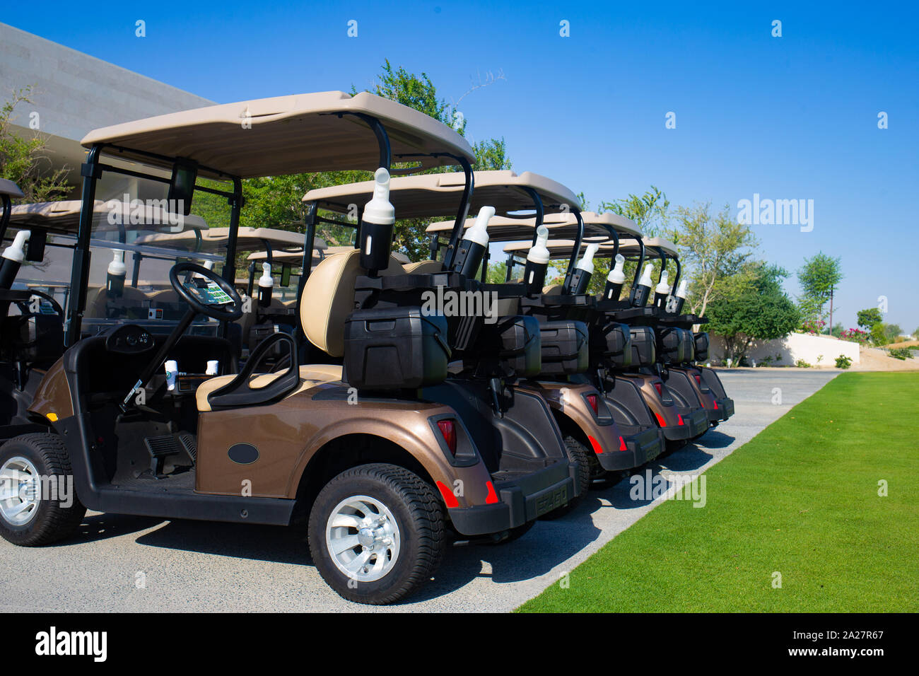 Golf cart on a golf closure.. Green field and cloudy blue sky. Spring ...