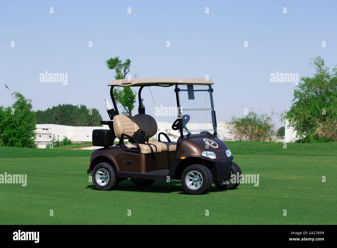 Golf cart on a golf closure.. Green field and cloudy blue sky. Spring ...