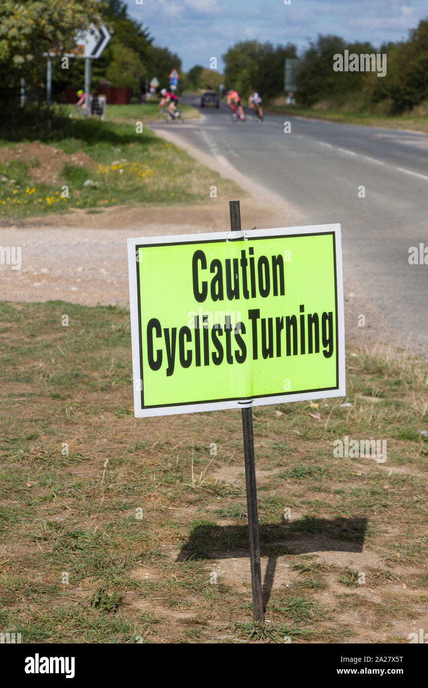 A "Caution Cyclists Turning" road safety cycling sign on a roadside ...